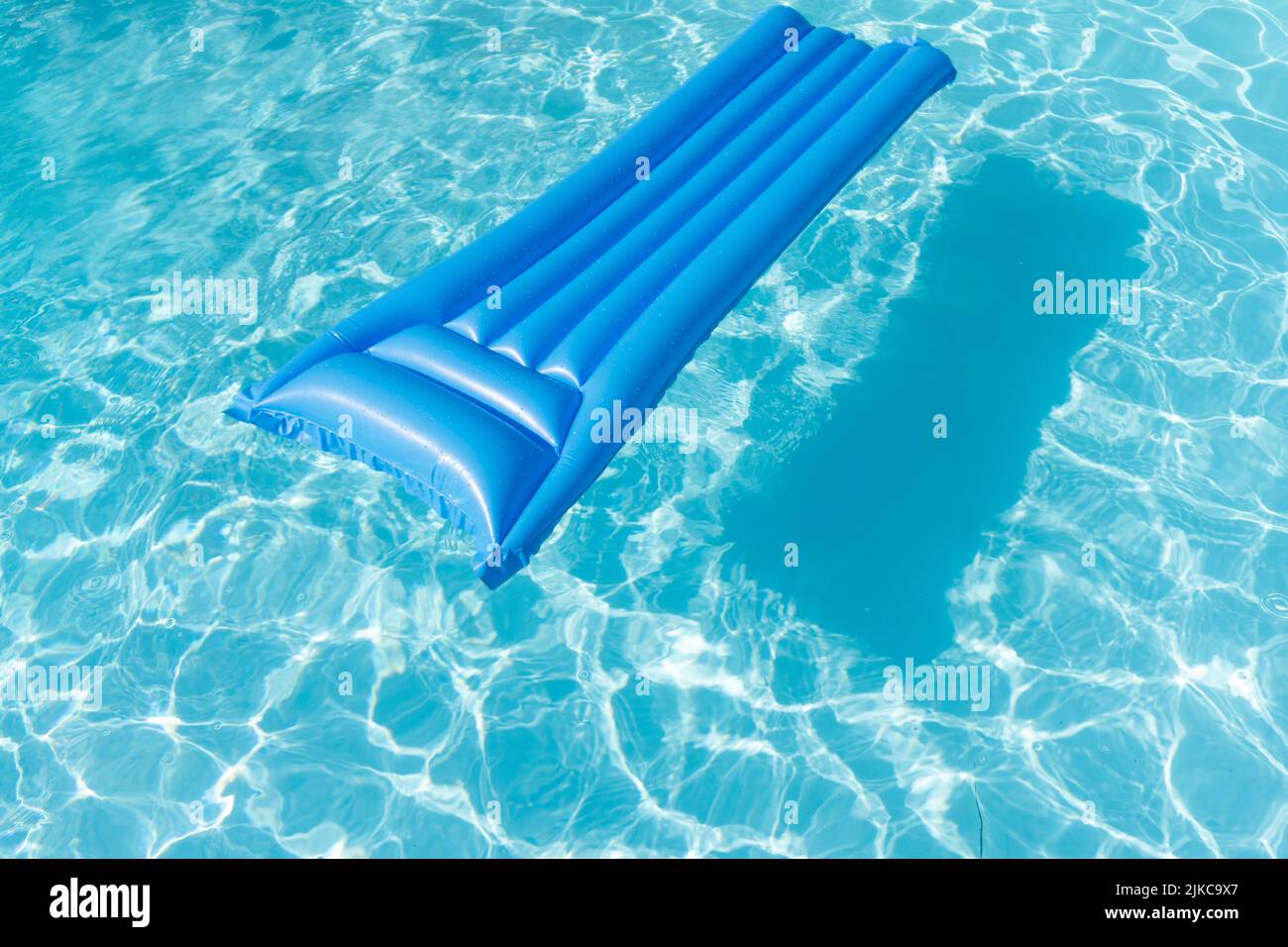Bright blue summer pool lounger float on a rippled swimming pool Stock ...