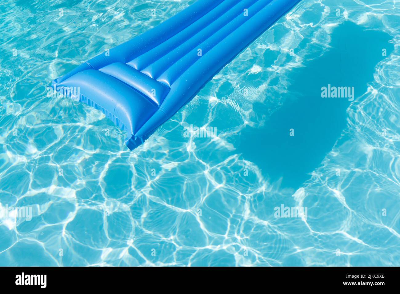 Bright blue summer pool lounger float on a rippled swimming pool Stock ...