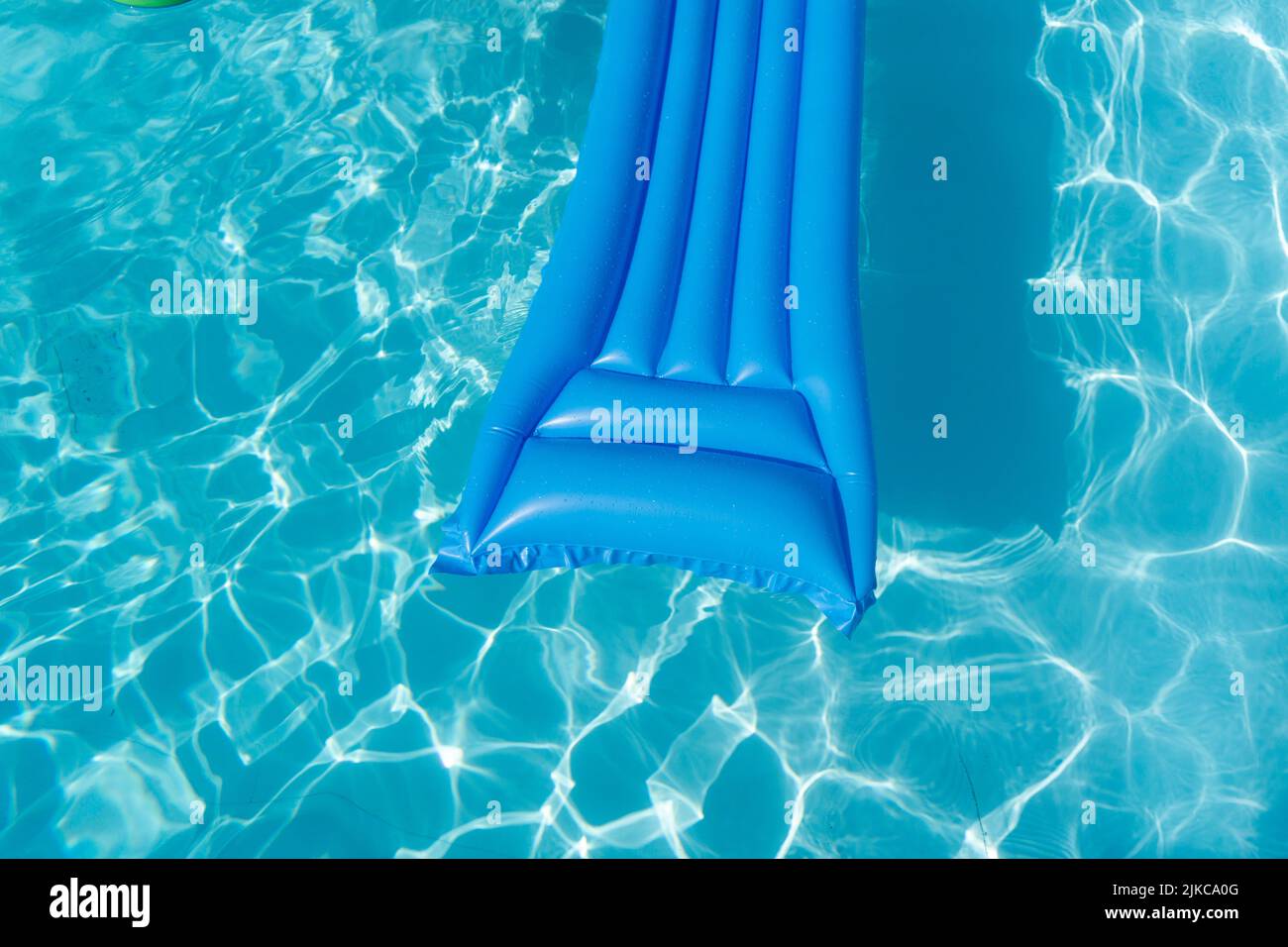 Bright blue summer pool lounger float on a rippled swimming pool Stock ...