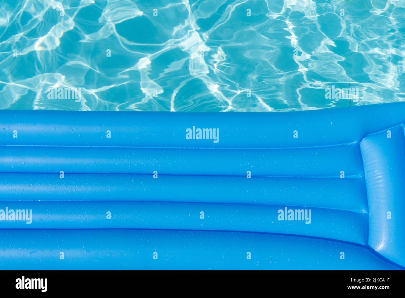 Bright blue summer pool lounger float on a rippled swimming pool Stock ...