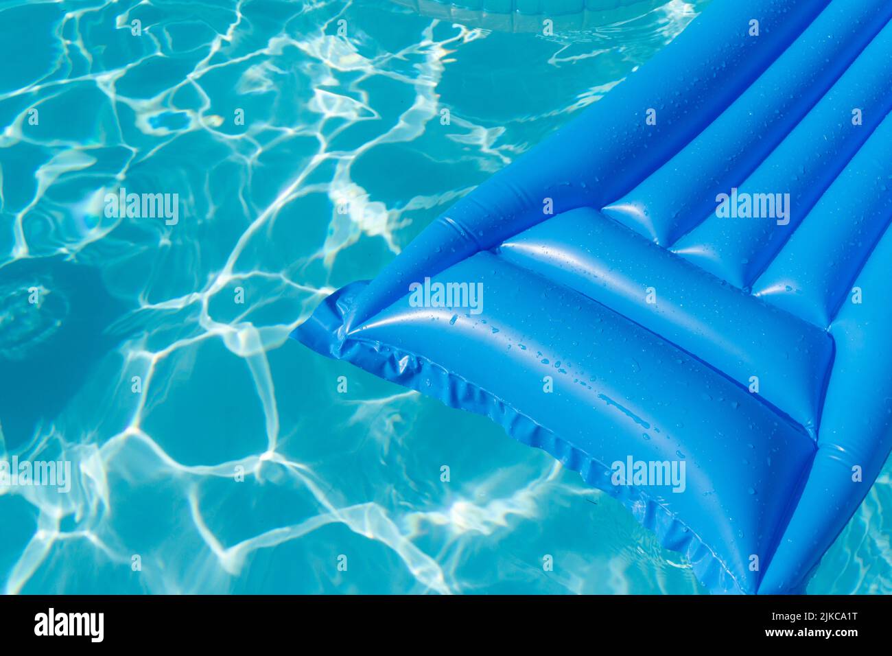 Bright blue summer pool lounger float on a rippled swimming pool Stock ...
