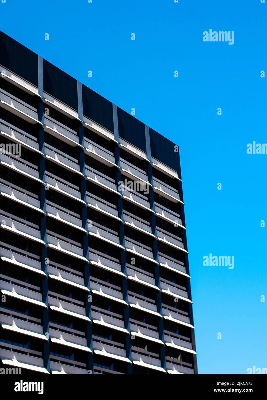 A vertical shot of a residential building block with balconies in blue ...