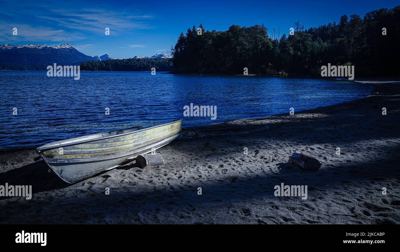 A simple wooden boat on the tranquil beach under the moonlight with a ...