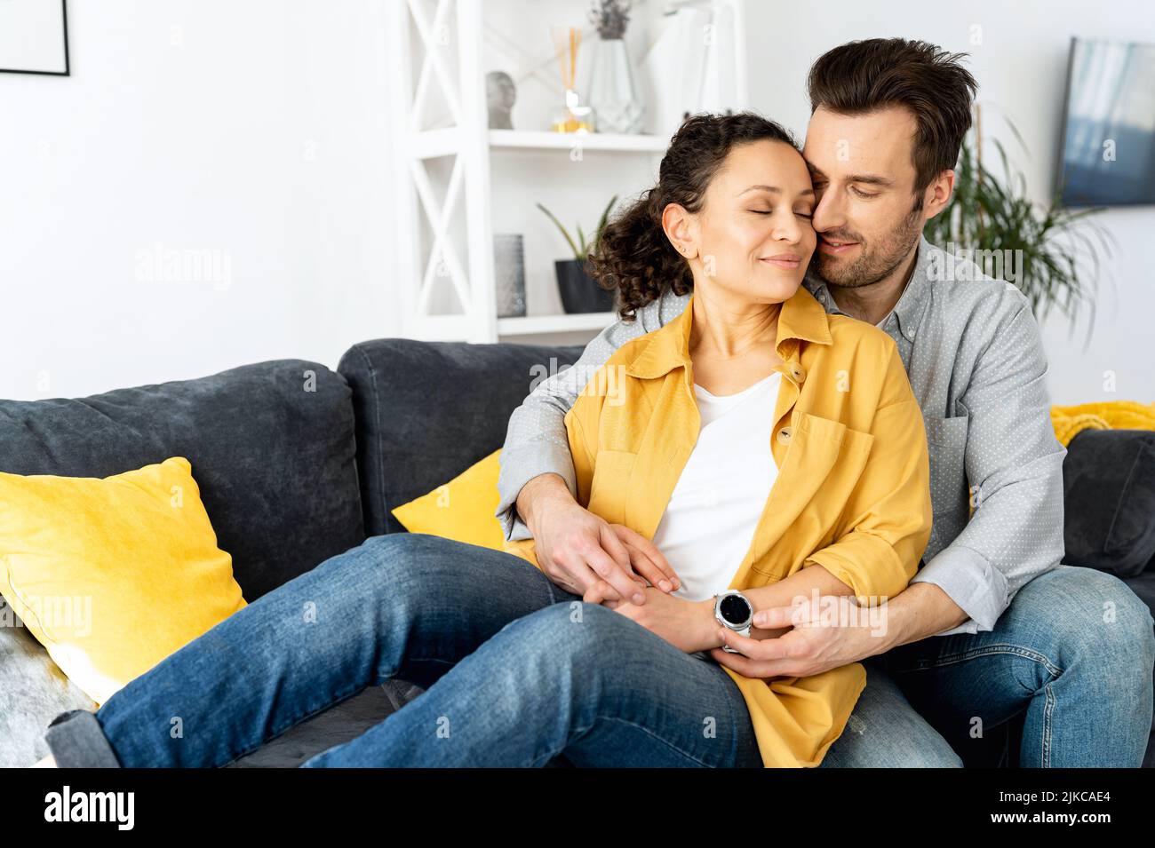 Gentle And Lovely Mid Aged Couple In Love Sitting In Embrace On The