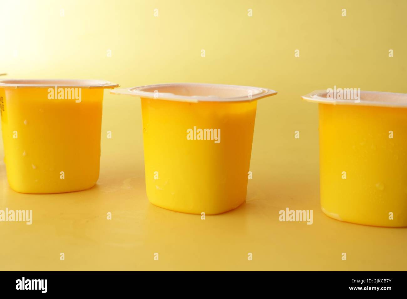 fresh yogurt in a yellow color plastic container Stock Photo - Alamy