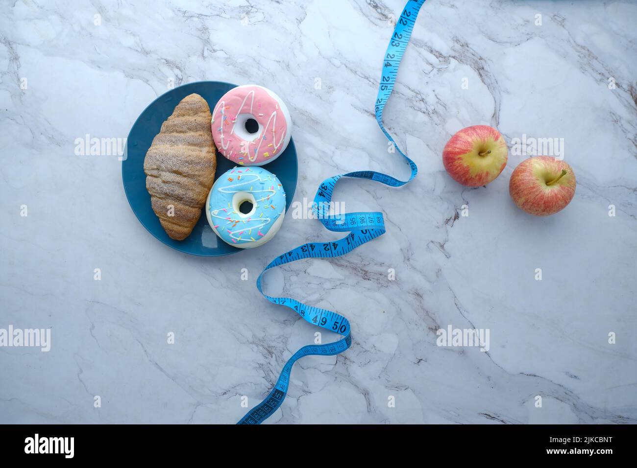 comparing donuts and apple, healthy diet concept Stock Photo - Alamy