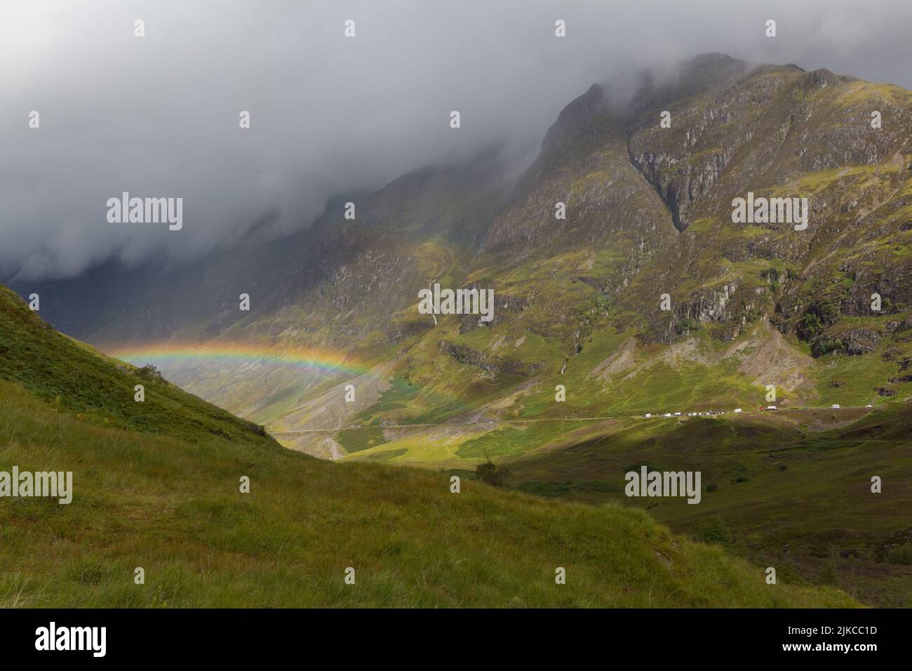 A dramatic landscape with a bright rainbow over green hills Stock Photo ...