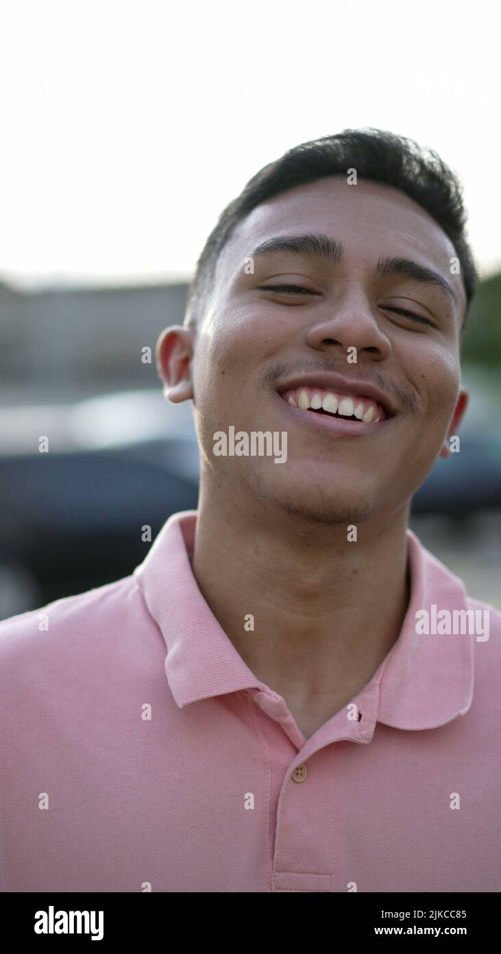 A confident Brazilian young man smiling at camera. A happy hispanic ...