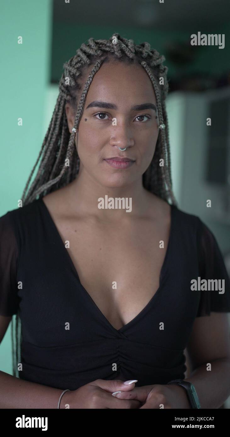 A confident black woman with dreadlocks hairstyle looking at camera ...