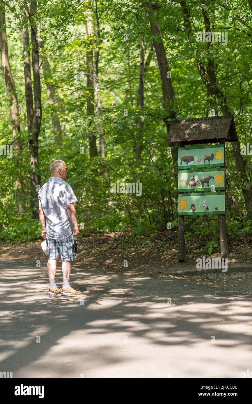 A man looking at a board showing directions to different animals in the ...