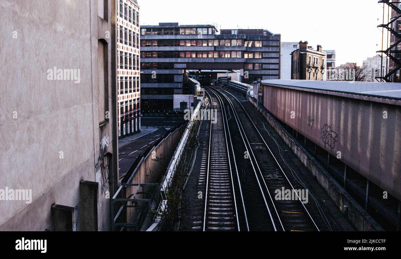 The railway in a modern city going through the building Stock Photo - Alamy