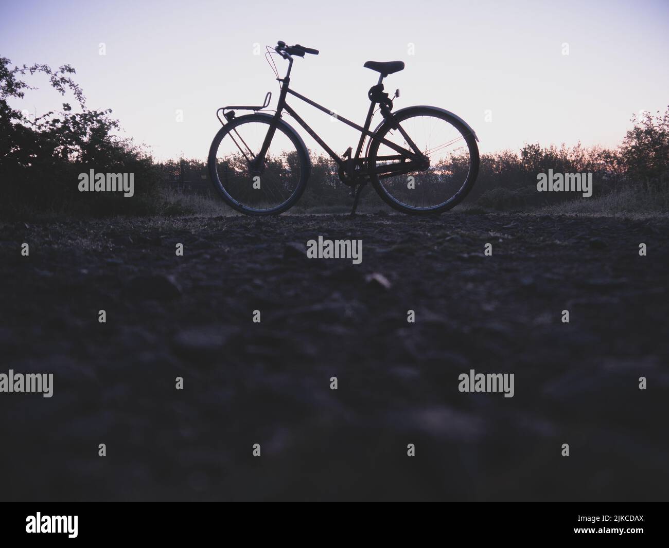 A low angle of a bike parked in the field during sunrise Stock Photo ...