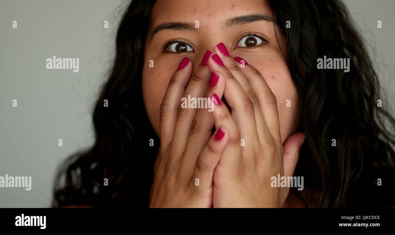 Hispanic girl shock surprise reaction covering mouth with hands Stock ...