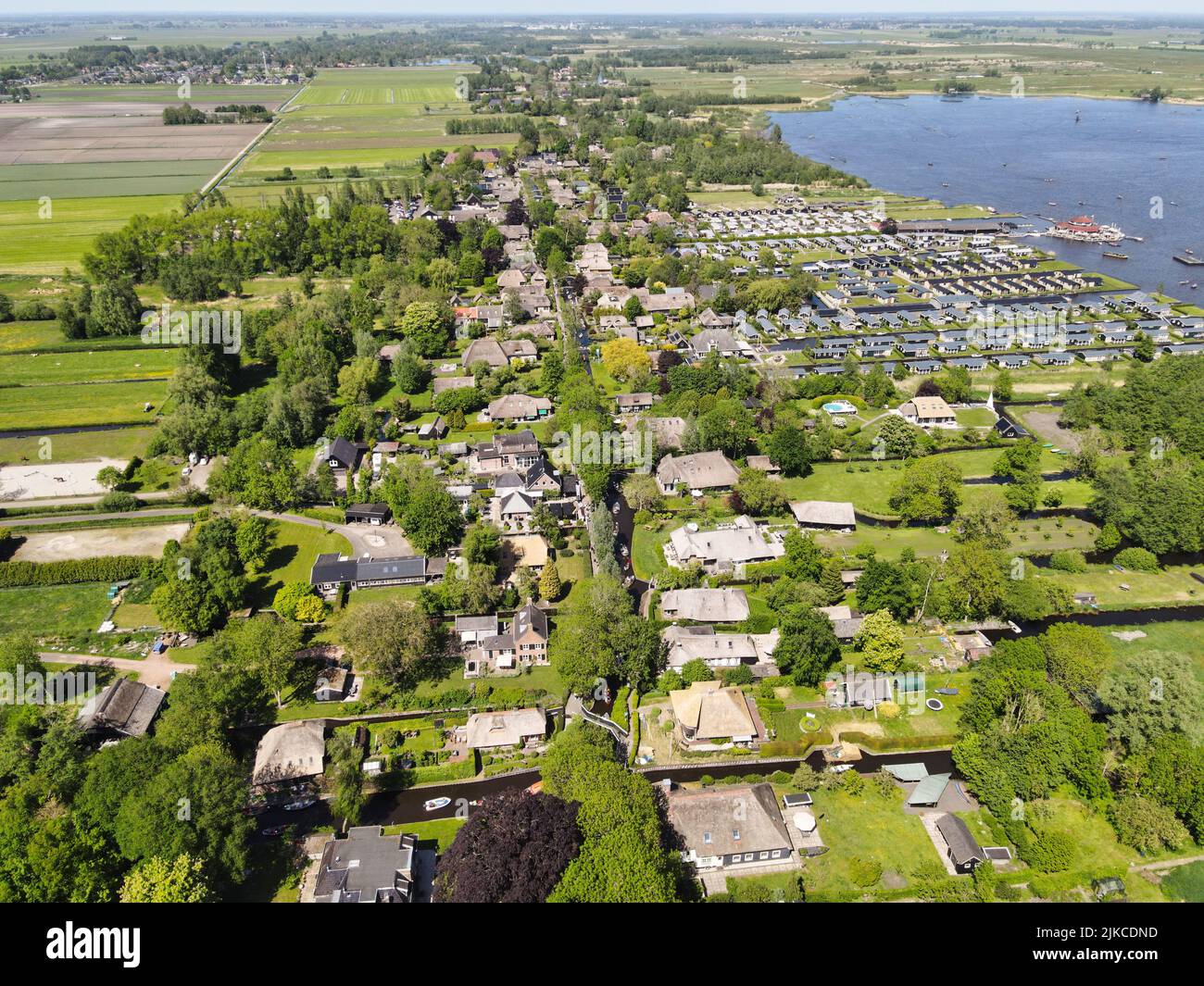 An Aerial shot of Giethoorn village with houses and green trees in a ...