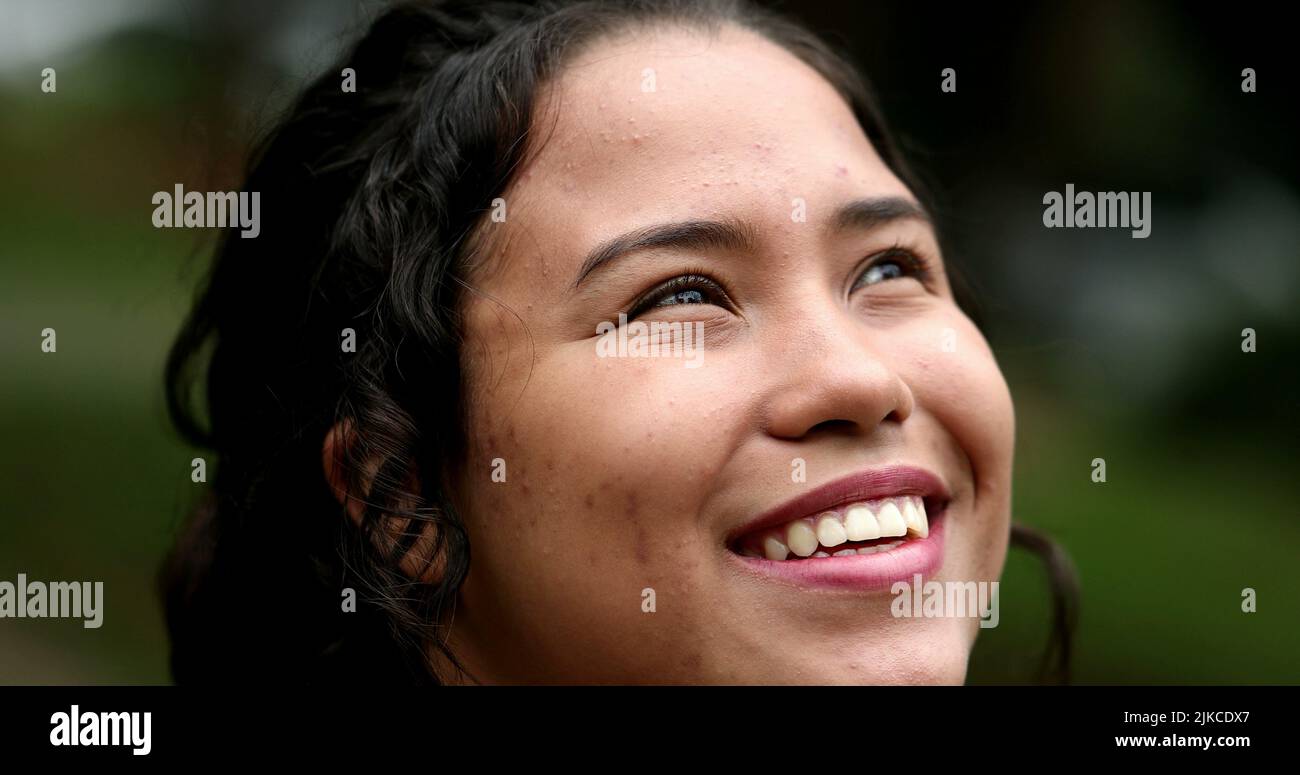 Latina girl looking at sky smiling. Hispanic young woman close-up face ...