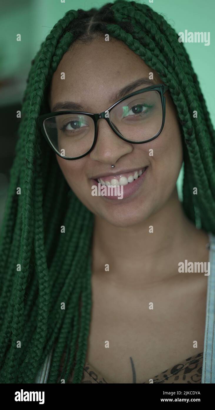 A young latin hispanic black girl with green dreadlocks smiling at camera. African woman with ...