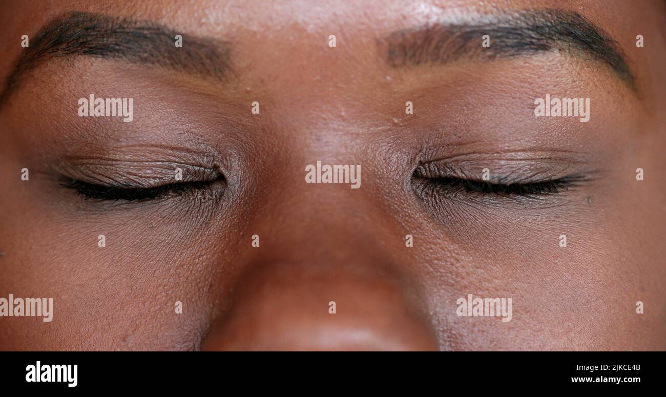 Meditative young black woman closing eyes in contemplation. Macro close ...