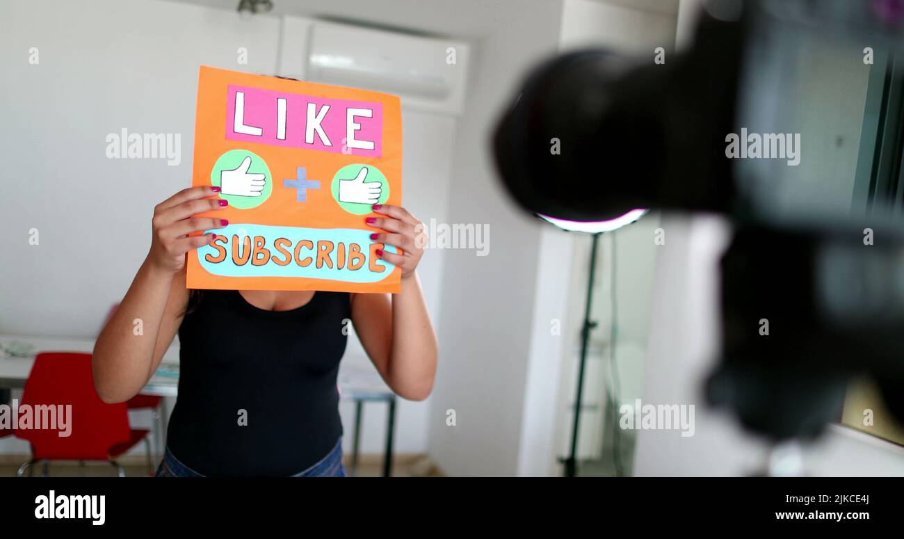 Millennial girl vlogger talking to camera showing sign for audience to ...
