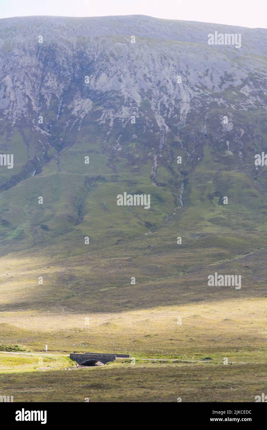 A vertical shot of a giant mountain and fields, The Isle of Skye ...
