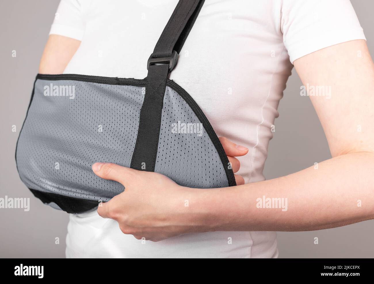 Woman wearing sling to support painful wrist. Arm strain, injury caused ...