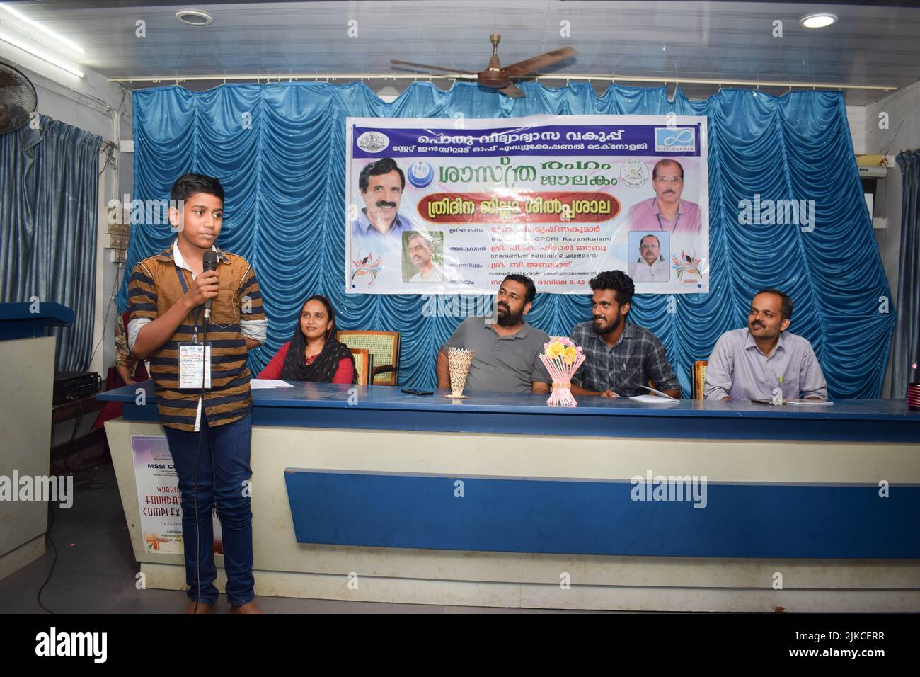 Indian boy talking in front of the class using a microphone or mike ...
