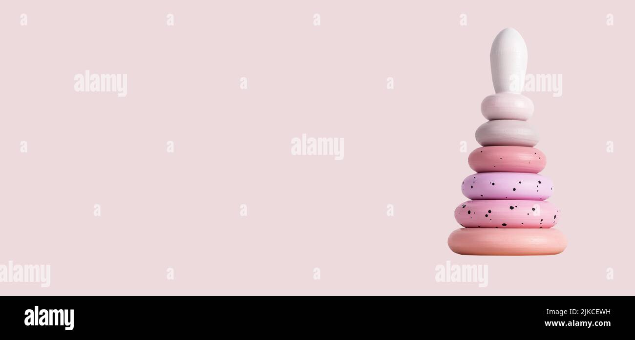 Banner with wooden pastel kids pyramid on pink background. Toy for ...