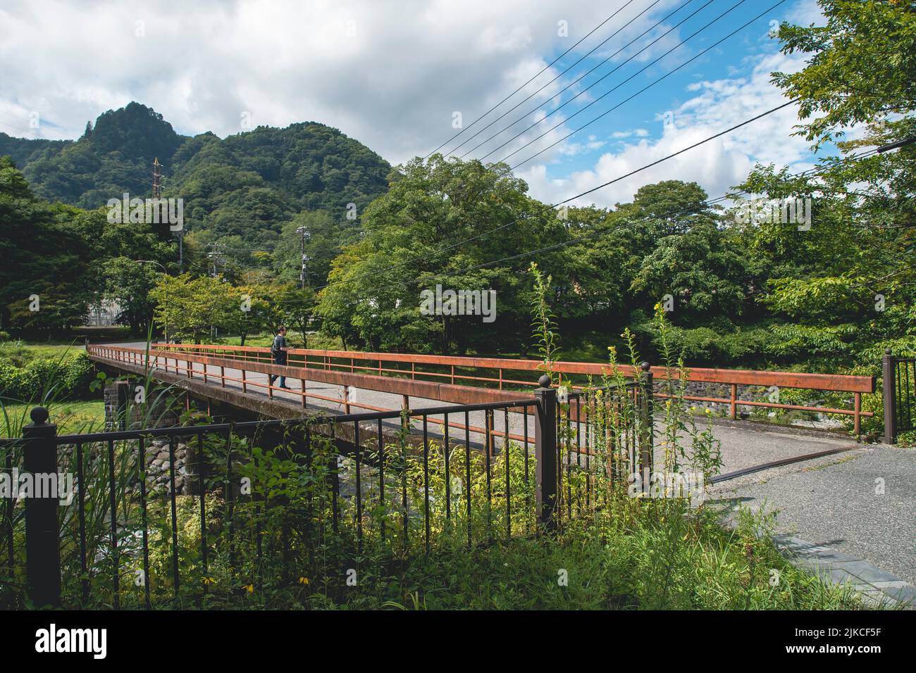A man crossing a bridge in the forest Stock Photo - Alamy