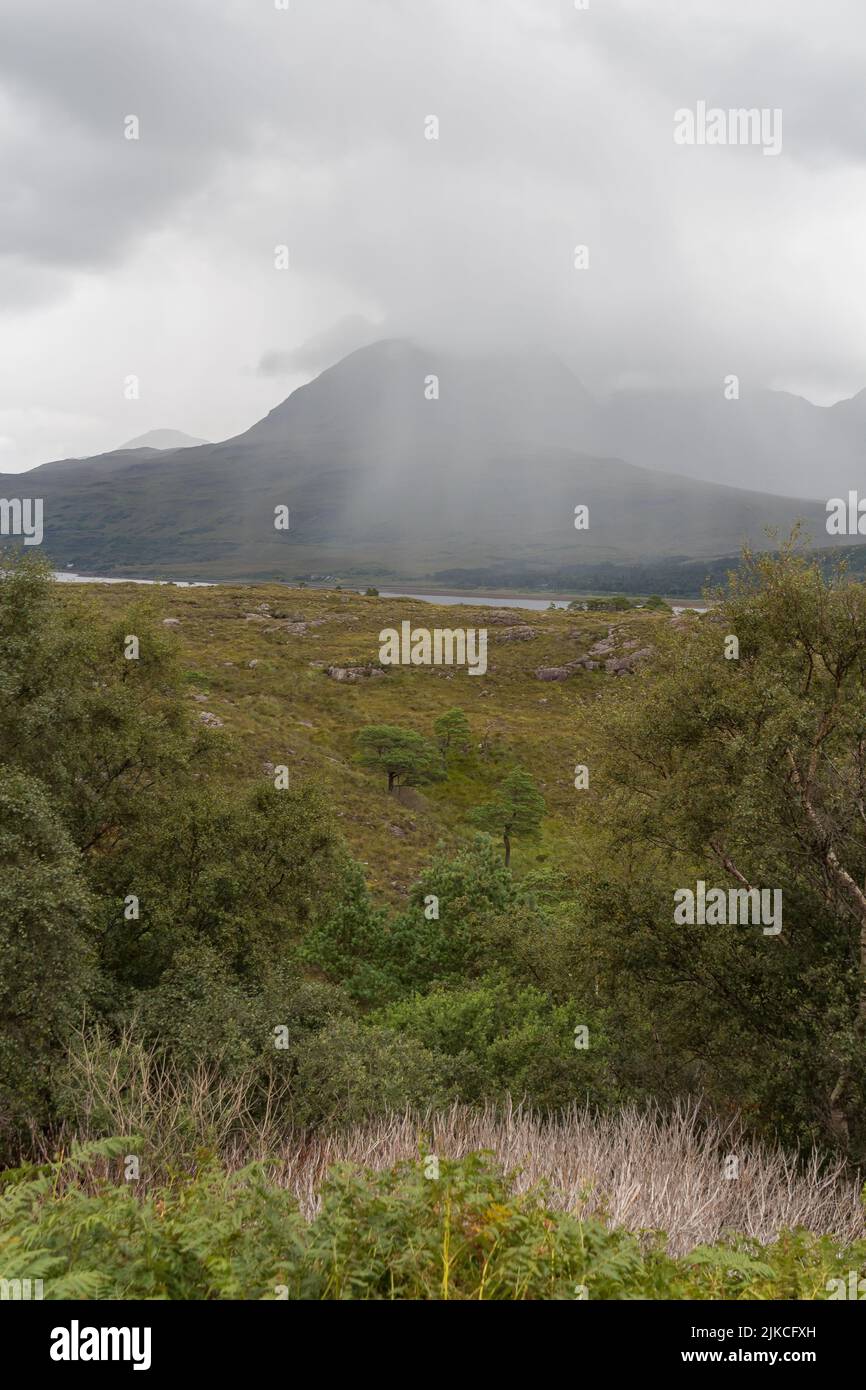 A vertical shot of Scottish Highlands on a foggy day Stock Photo - Alamy