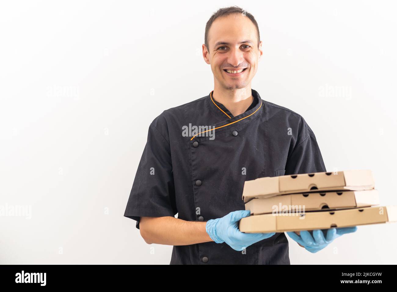 A chef in uniform offering you a pizza box. Smiling at camera Stock ...