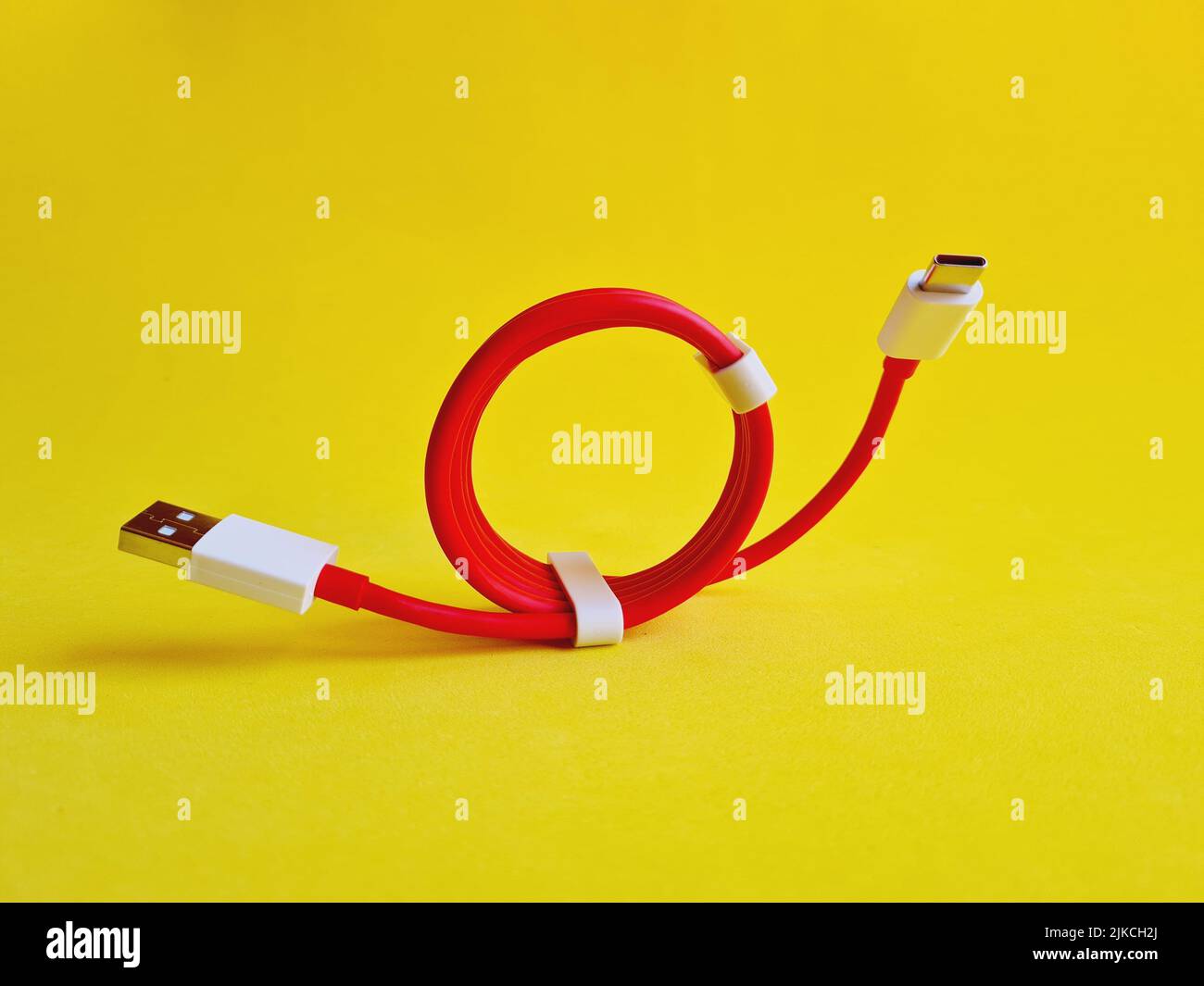 A new red cable with white ends resting on a yellow background - the ...