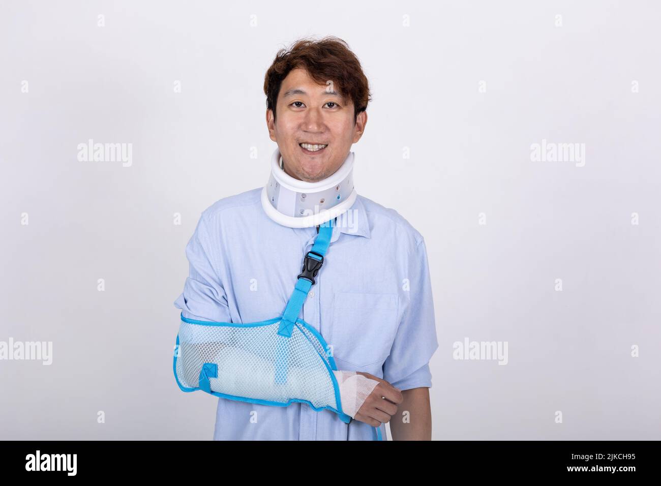 Portrait of a smiling handsome Asian man with broken arm and neck ...