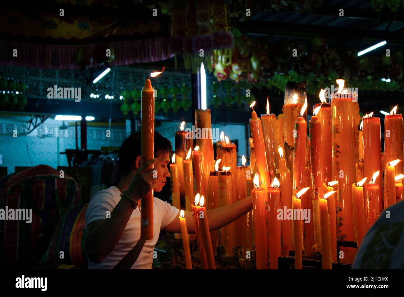 The man lighting up candles for The Chinese festival in Talad Noi ...