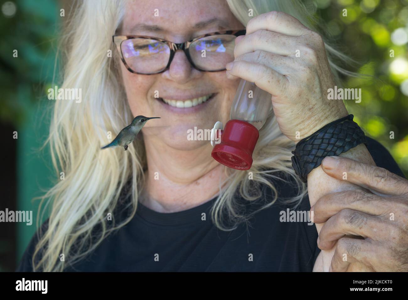 Hummingbird feeder woman hi-res stock photography and images - Alamy