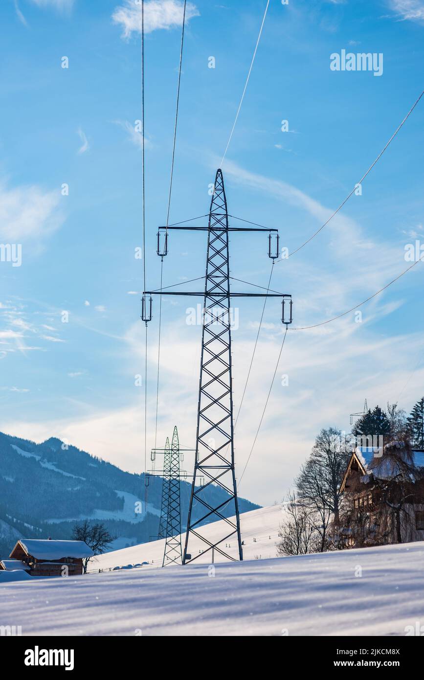 High voltage power pole with an overhead line. Winter scenery around ...