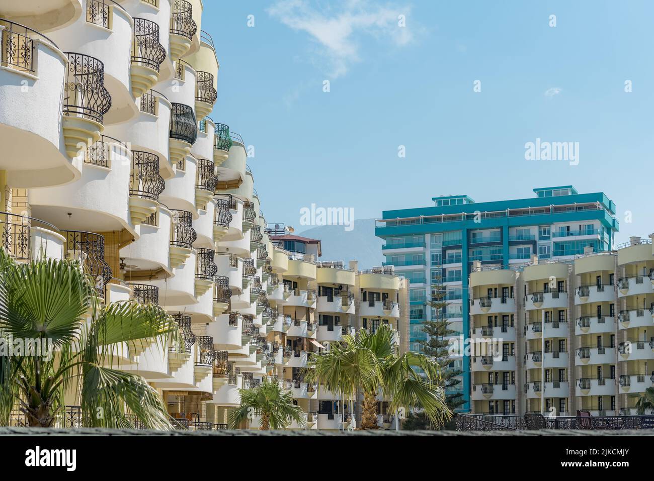 Residential complex with palm trees and mountain views. Urban landscape ...
