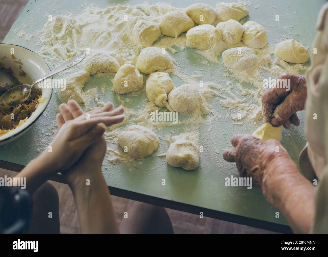 Old and young hands making patties Stock Photo - Alamy