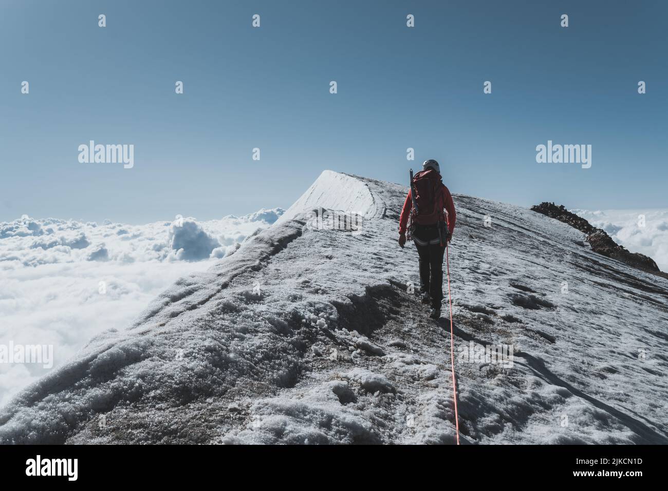 Female mountaineer climbing last meters over ridge towards summit Stock ...