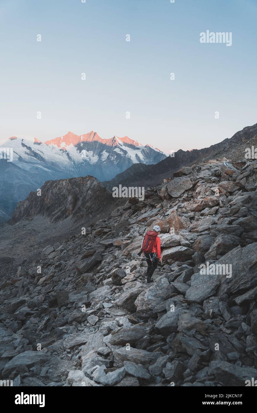 Female climber scrambling through rocky terrain to climb Weissmies ...