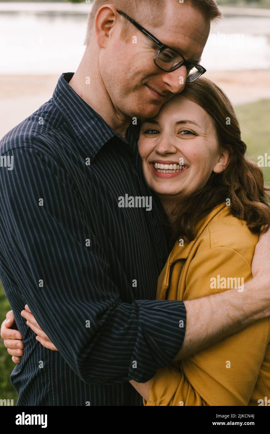Adult married couple hugs and smiles on lakeshore Stock Photo - Alamy