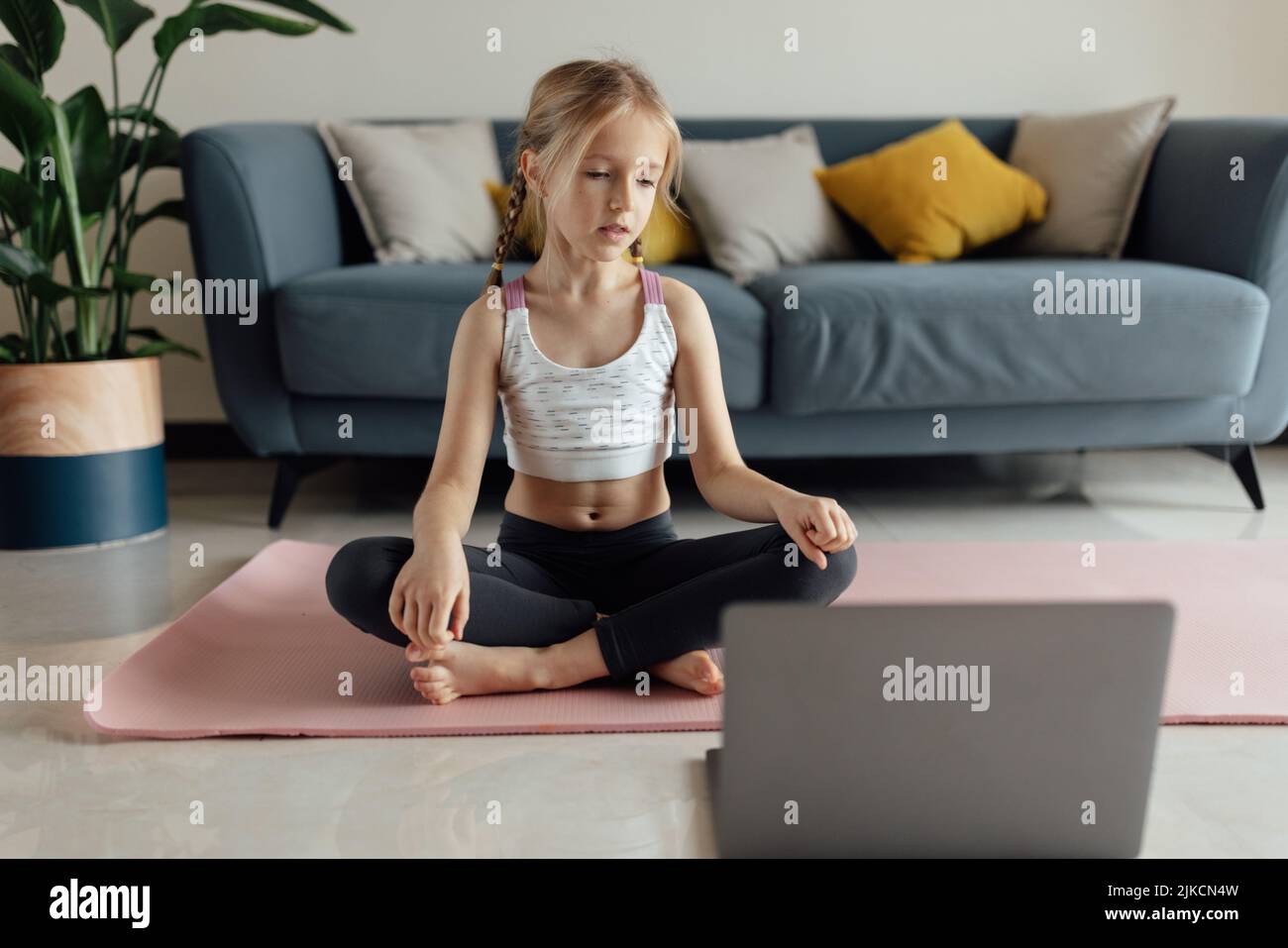 Pretty caucasian little girl in sportswear watching online video on ...