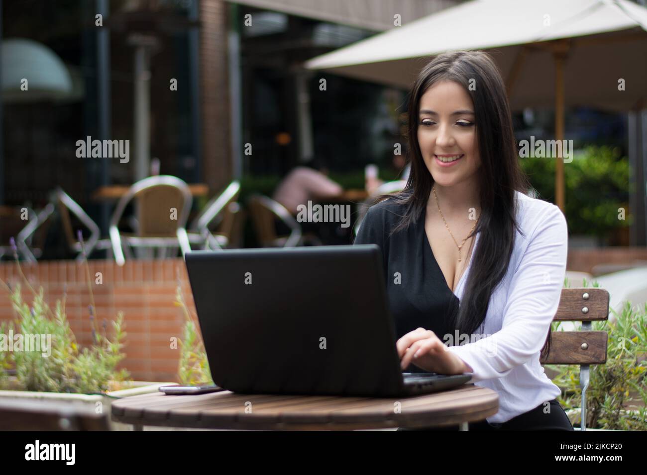 Young woman working outdoor, using a laptop computer in a cafe Stock ...