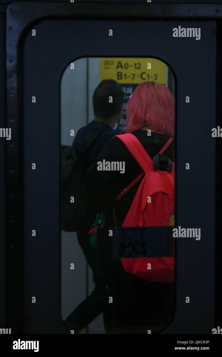 A vertical of people with backpacks standing in an underground train ...
