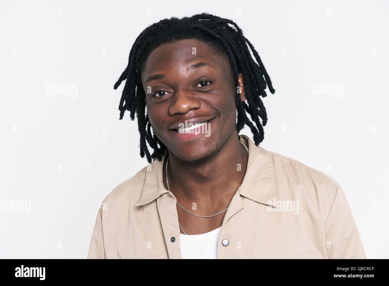 Young black man with dreadlocks smiling and looking at camera isolated ...