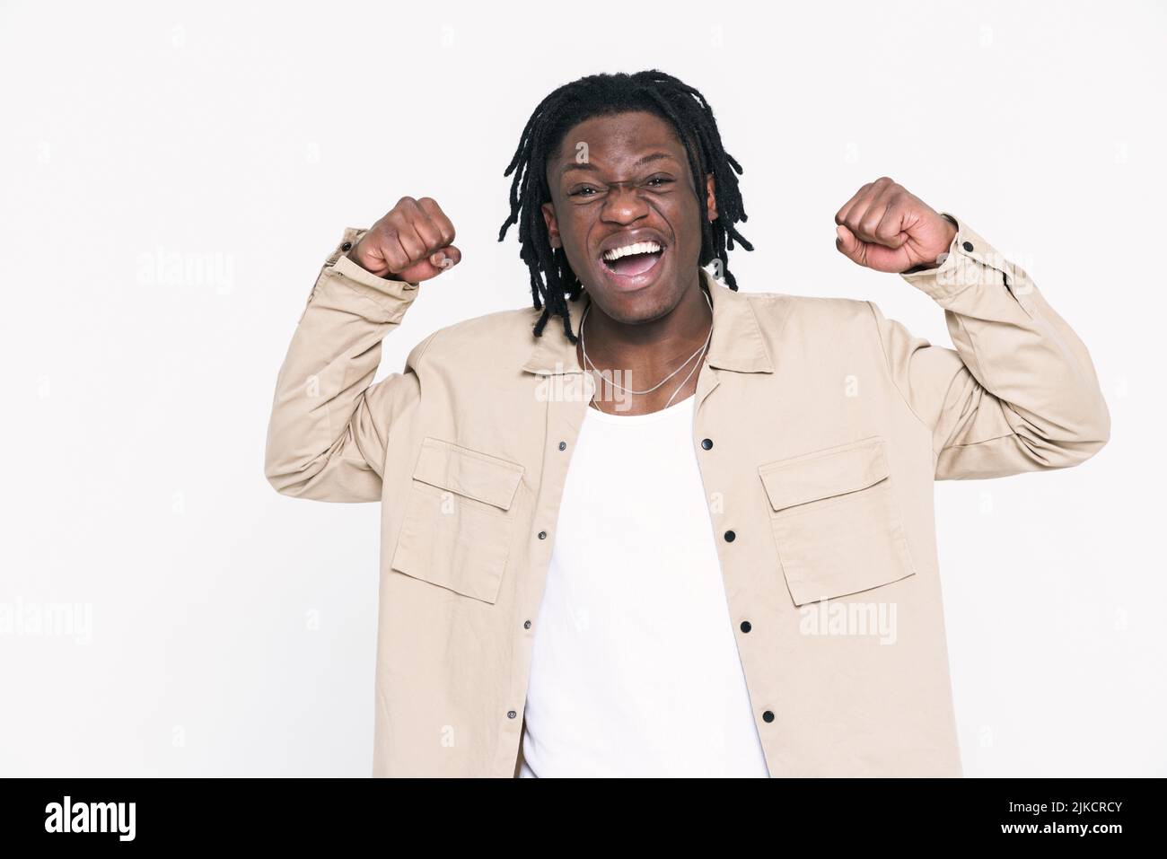 Black man with dreadlocks screaming while making winner gesture ...