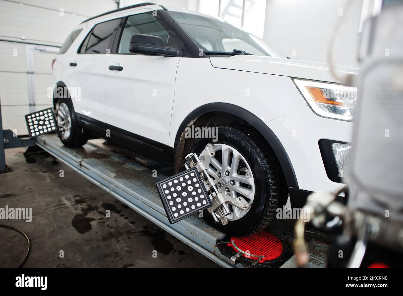 American SUV car on stand for wheels alignment camber check in workshop ...