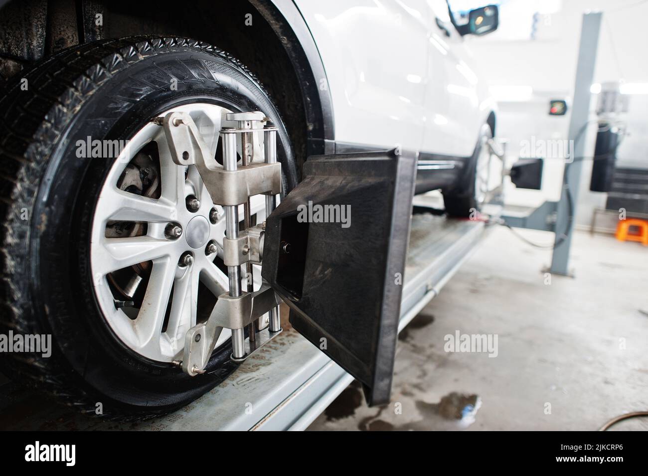 American SUV car on stand for wheels alignment camber check in workshop ...