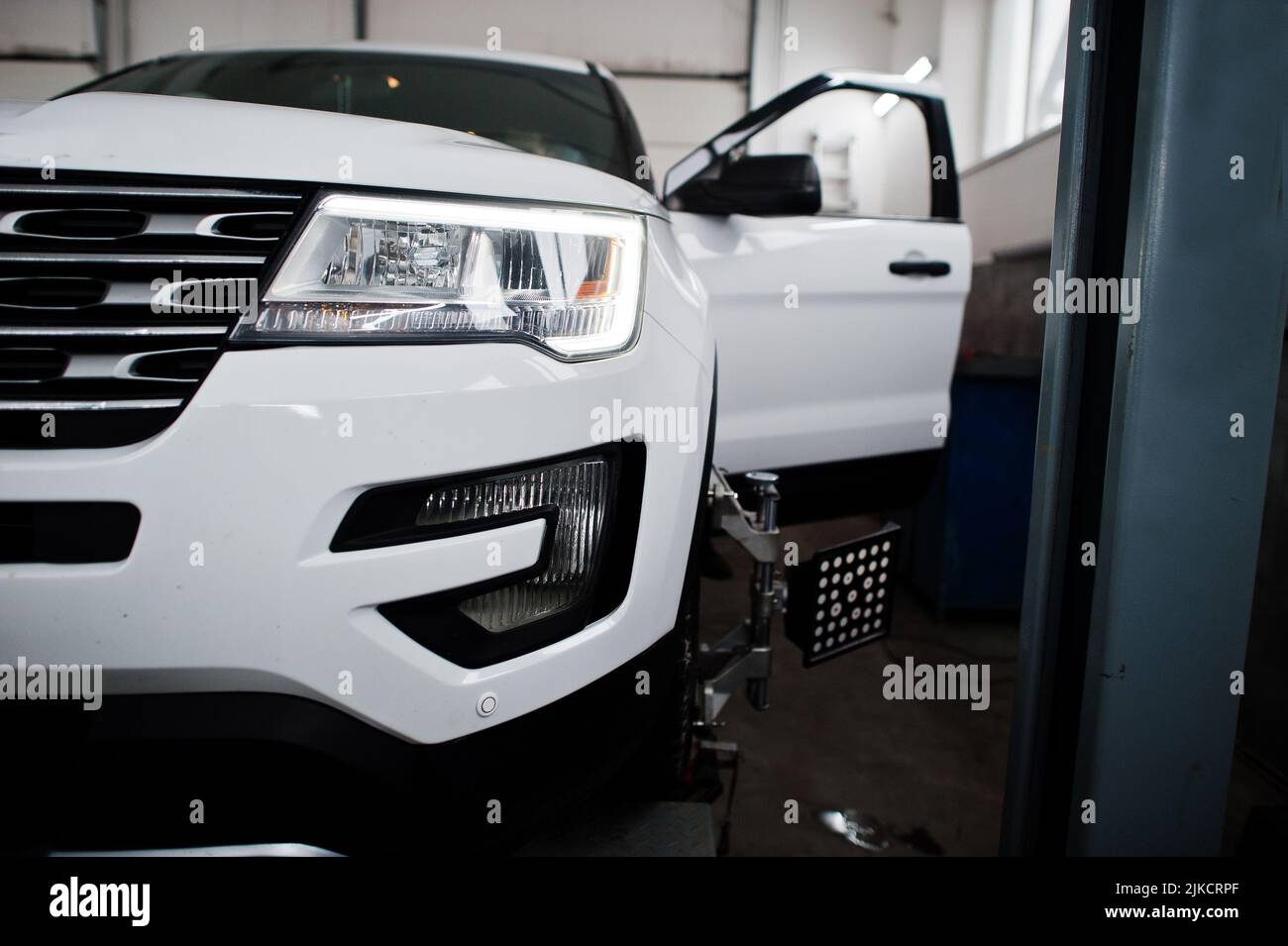 American SUV car on stand for wheels alignment camber check in workshop ...