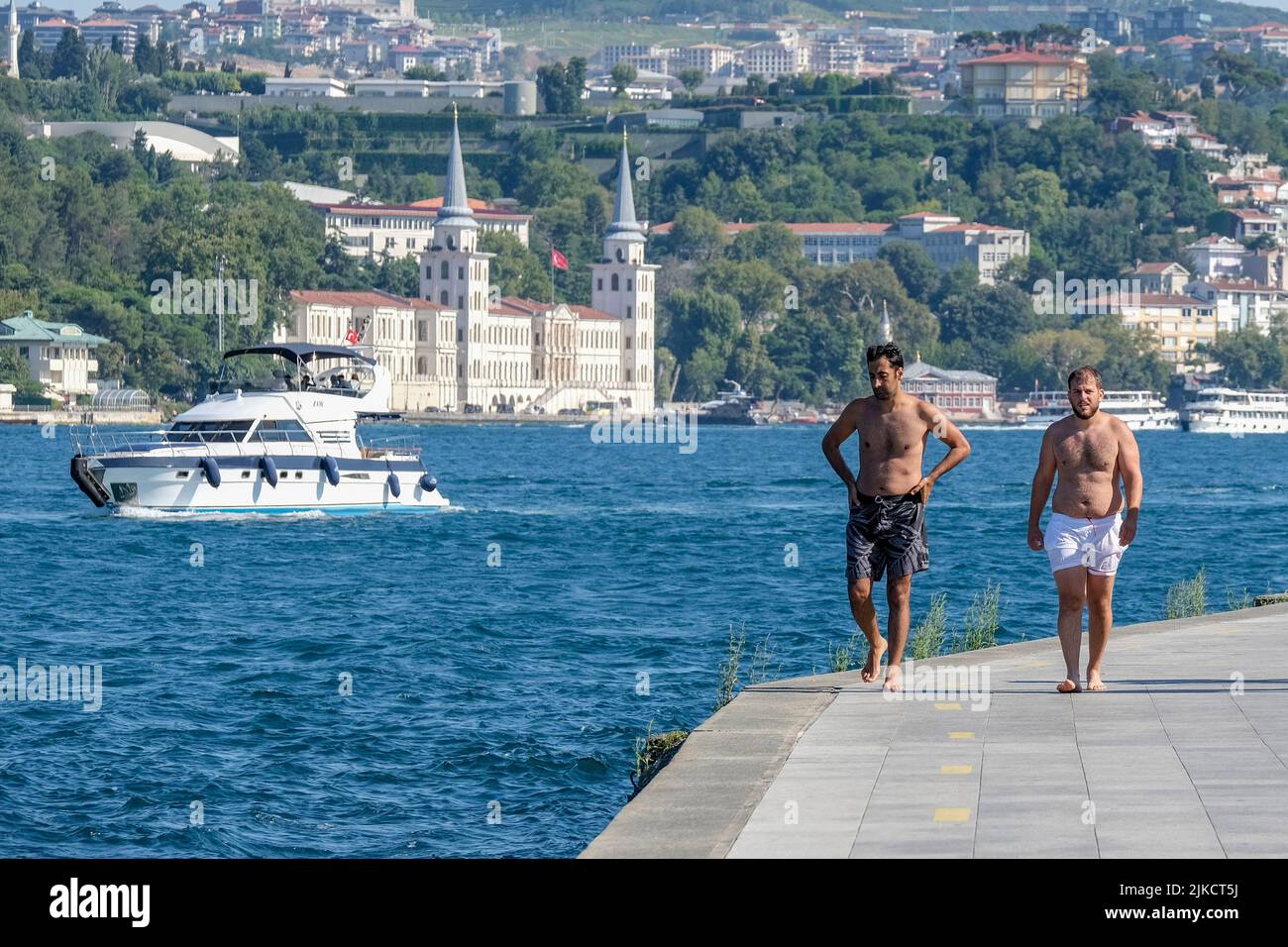 Young men seen enjoying at Bosphorus sea. Citizens sweating in the heat ...