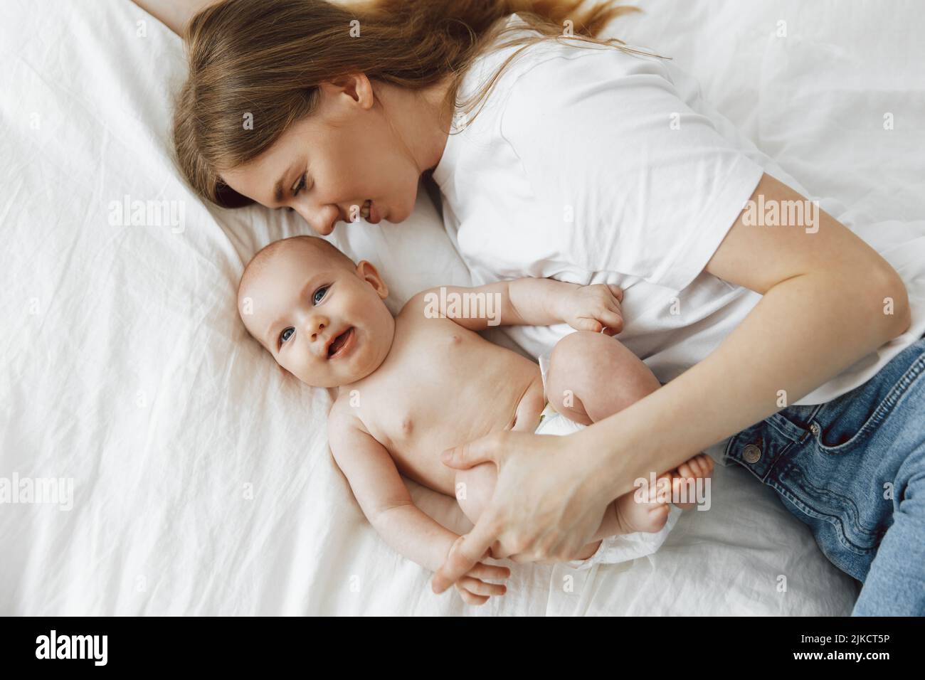 Hugging newborn baby on bed hi-res stock photography and images - Alamy