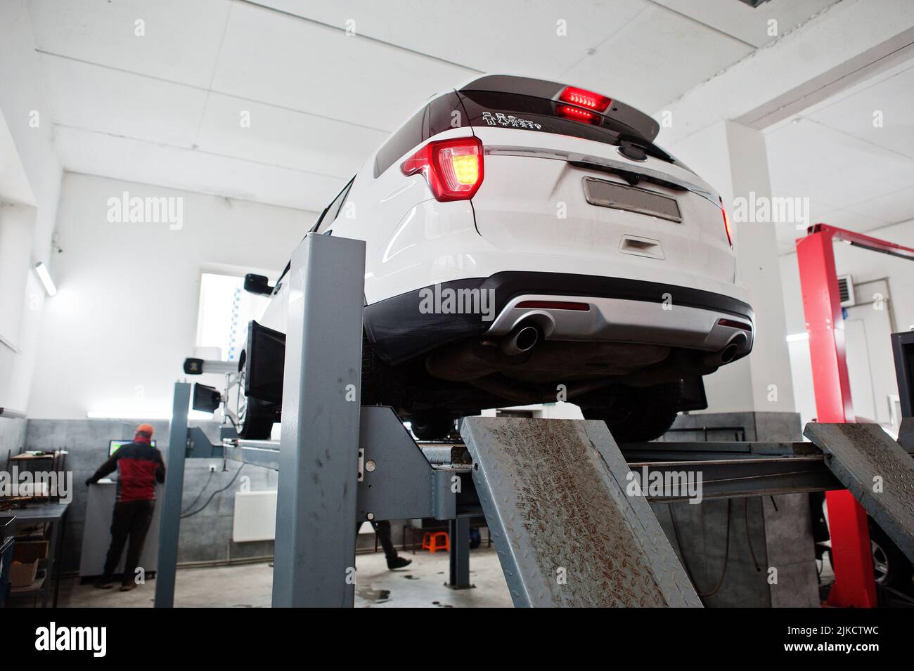 American SUV car on stand for wheels alignment camber check in workshop ...